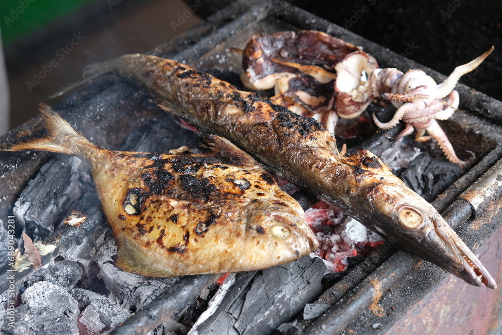 grouper, pomfret, barracuda, squid grilled on a charcoal grill. grilled ...