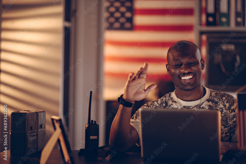 American soldier having a video call on his laptop while deployed in an ...
