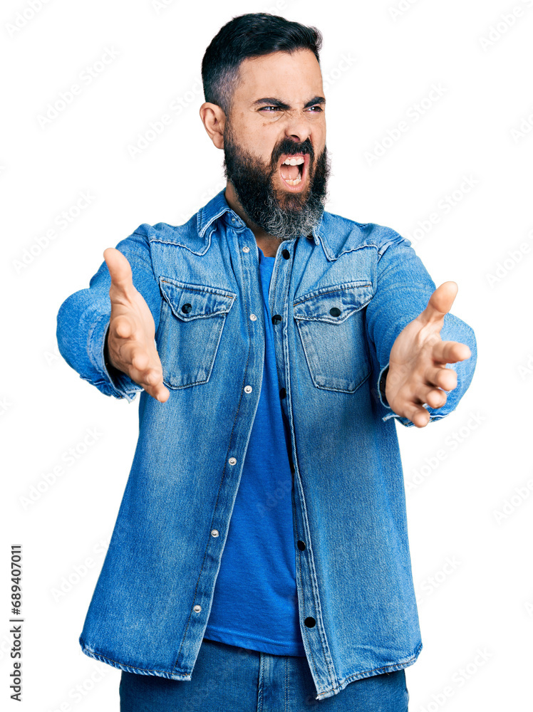 Hispanic man with beard with open arms doing hug gesture angry and mad ...