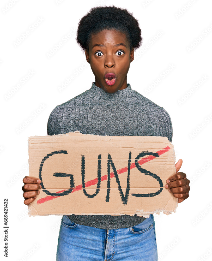 Young african american girl holding no guns warning banner scared and ...