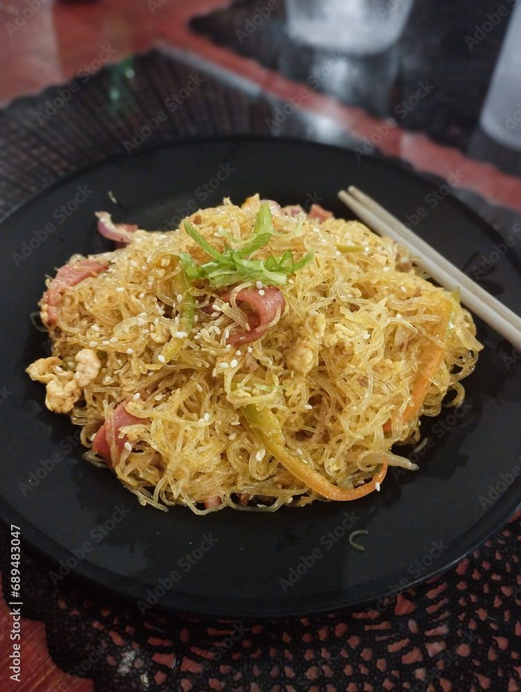Close up to a plate of pancit bihon or Filipino stir-fried rice noodles ...