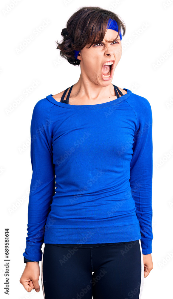 Beautiful young woman with short hair wearing training workout clothes ...