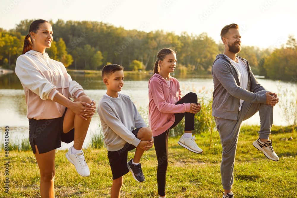 Fit and active happy parents with two kids boy and girl doing sport ...