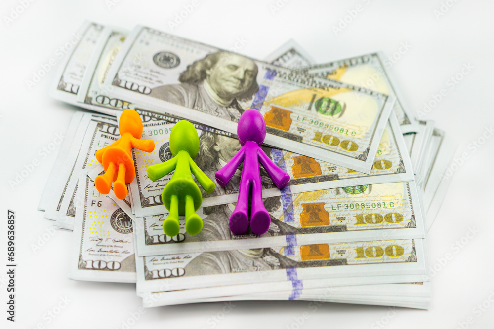 100 dollars and a colorful silicone faceless family toy on top of them ...