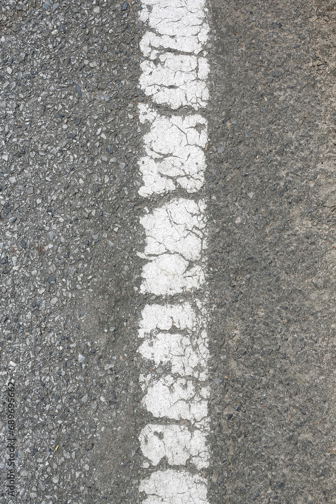 Cracked white dividing line on asphalt road. Old worn white road line ...