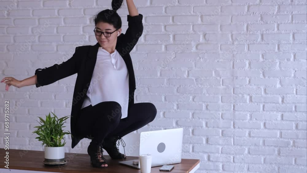 Cheerful office worker dancing on desktop in front of laptop ...