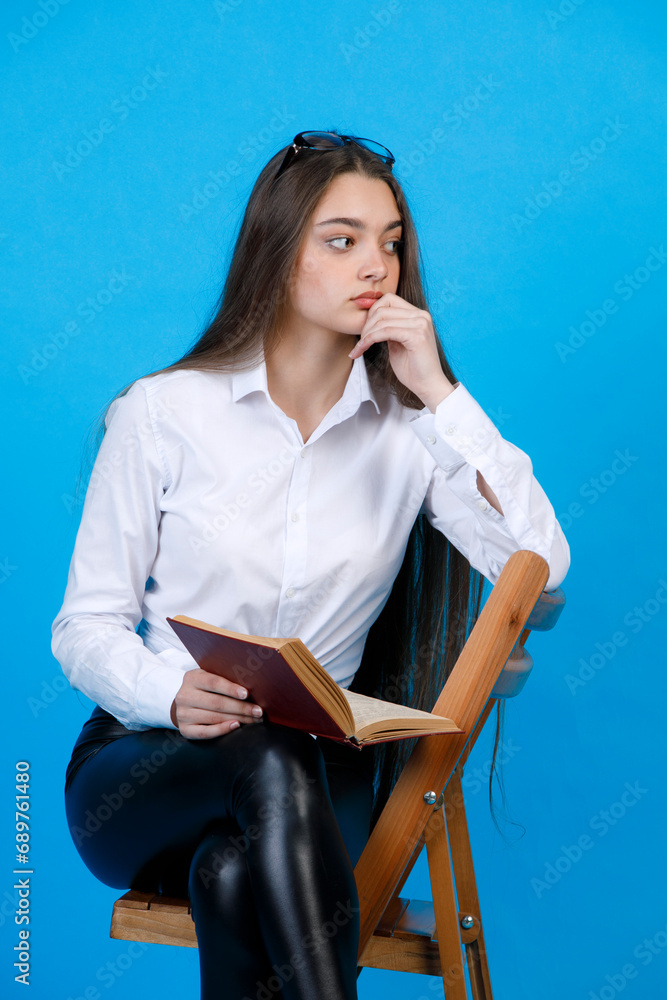 Thoughtful nice woman with loose hair, touching lips with hand, while ...