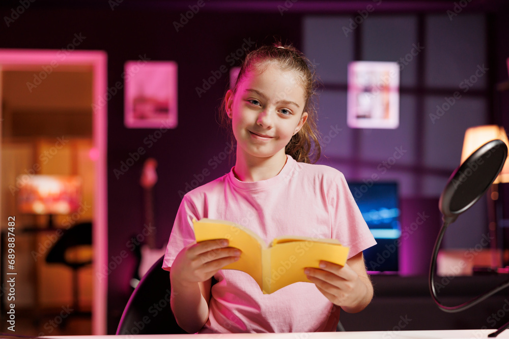 Kid influencer in studio reading newly released hardcover book from ...