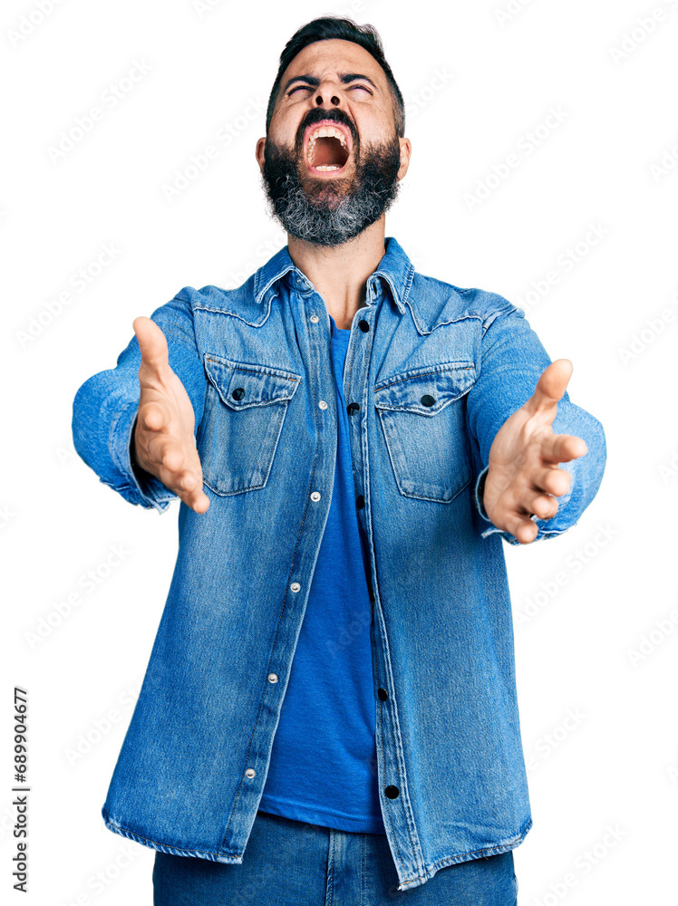 Hispanic man with beard with open arms doing hug gesture angry and mad ...
