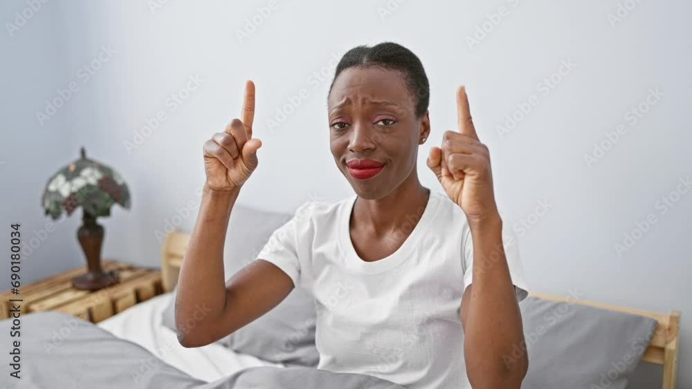 Depressed african american woman lying in bed, pointing up in an ... Depressed african american woman lying in bed, pointing up in an ...