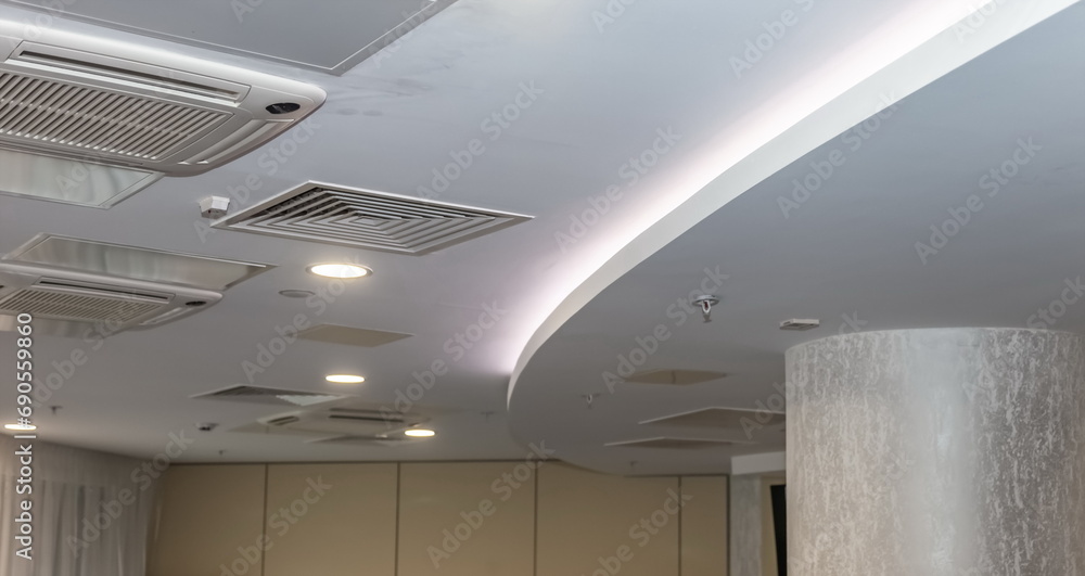 Office ceiling with ventilation grilles, lamps and air conditioners ...