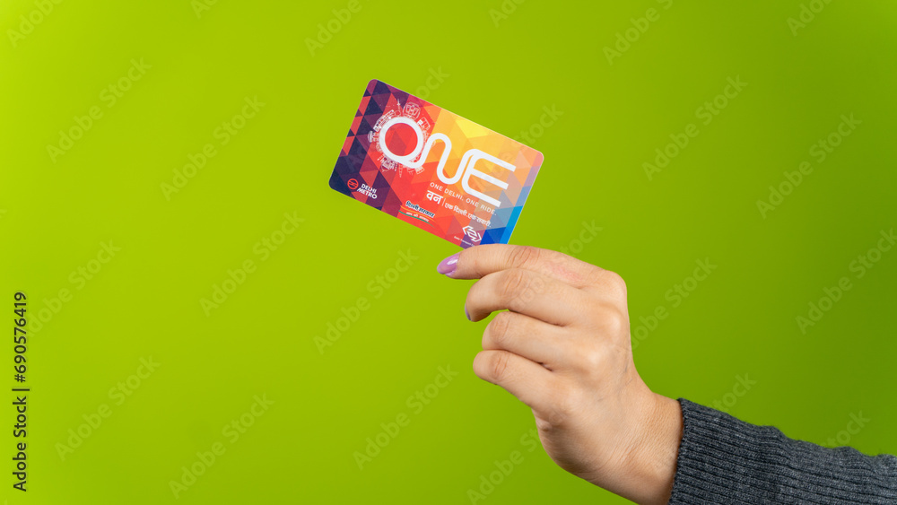 Delhi metro card against solid green screen background, girl holding ...