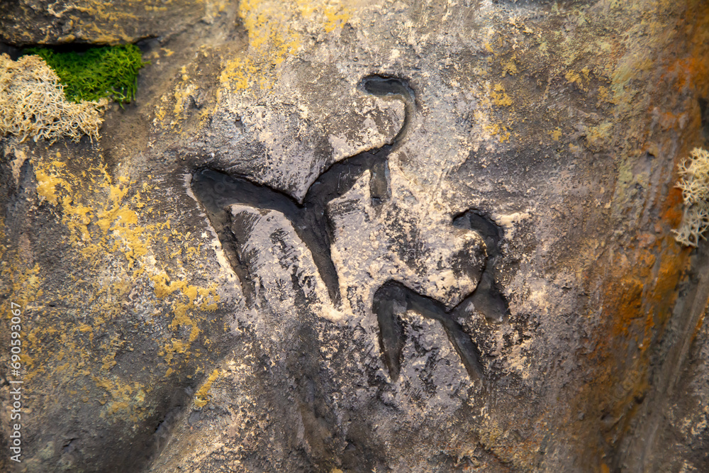 Black images of little men on the rocks on a clear sunny day ...