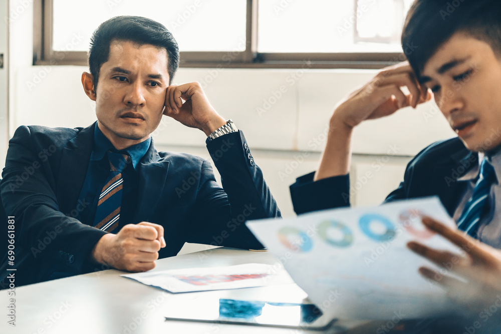 Unhappy business manager and young businessman partner in meeting room ...