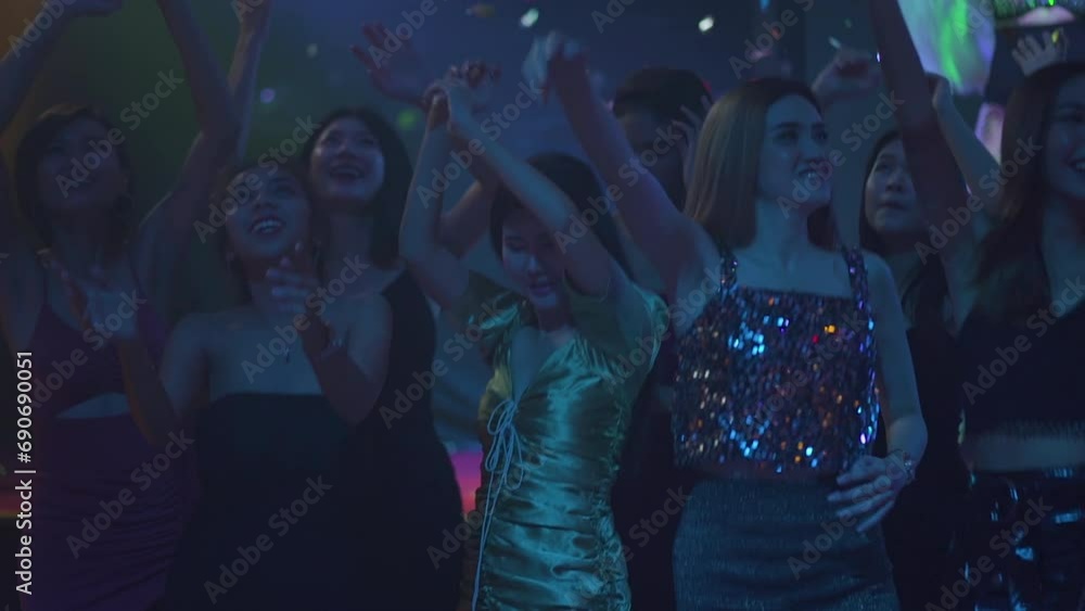 Cheerful young people dancing in night club with confetti at nightclub ...