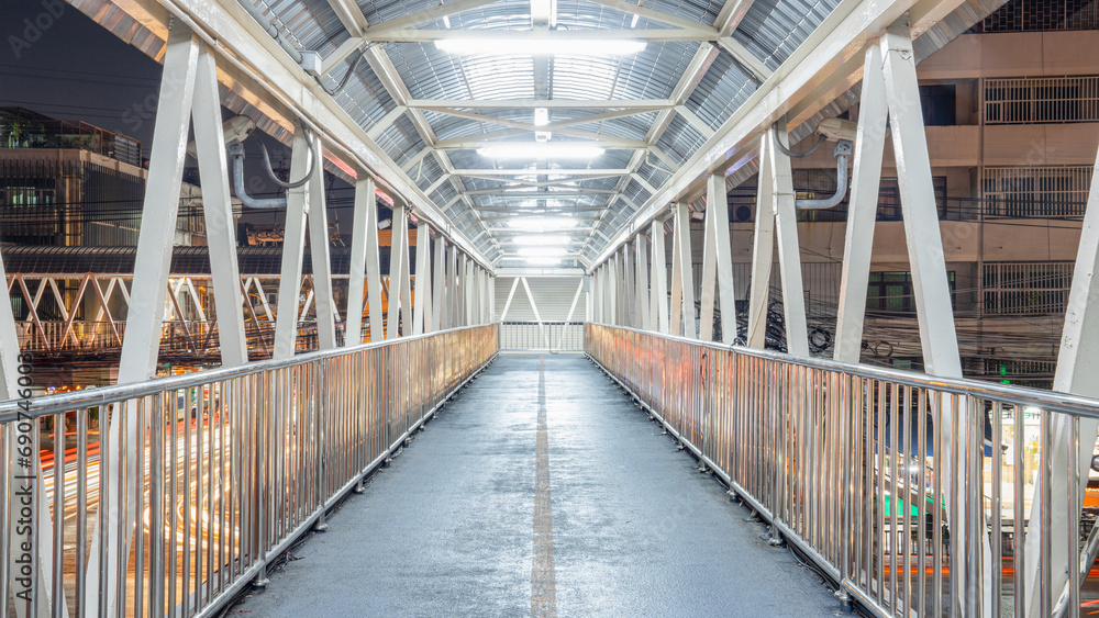 The walkway on the steel overpass in the capital at night looks clean ...
