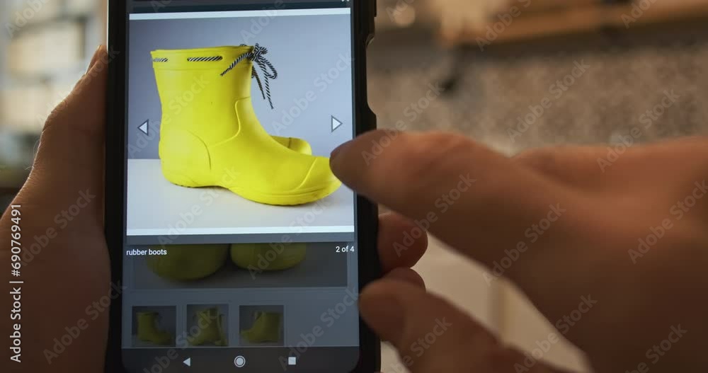 Examine pictures of shoes on smartphone screen. The concept of online ...