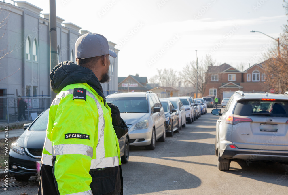 Security guard conducting access control, traffic control, and parking ...