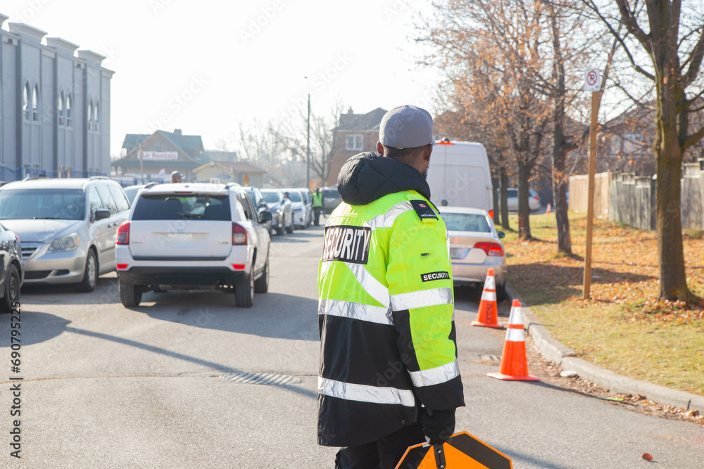 Security guard conducting access control, traffic control, and parking ...