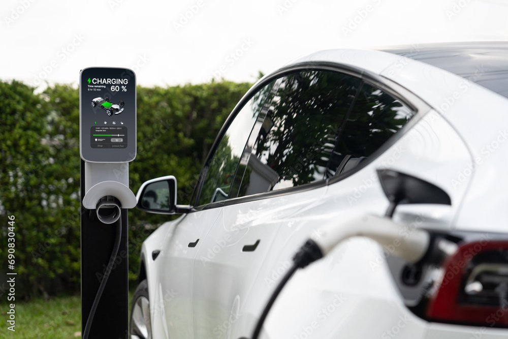 Closeup EV charger plug handle attached to electric vehicle port ...