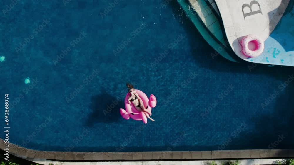 Young millennial woman swim chill on inflatable pink flamingo in luxury ...
