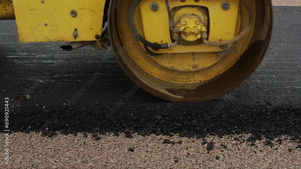 The process of road construction where an asphalt roller levels the ...