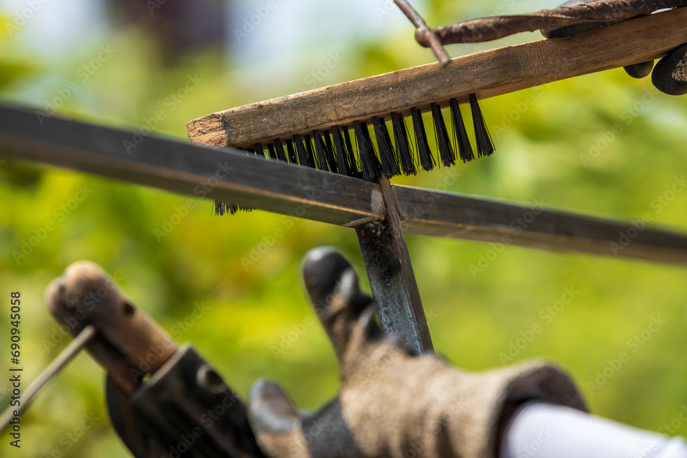 Welder cleans the welding surface using wire brush to remove residue ...