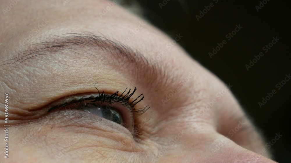 middle aged female's eye with drooping eyelid making eyebrow makeup ...