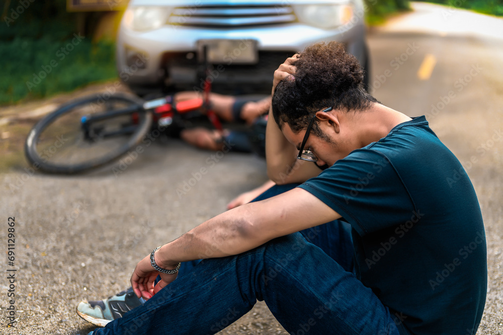 Fotka „Young Asian man sitting on the road worrying after driving car ...