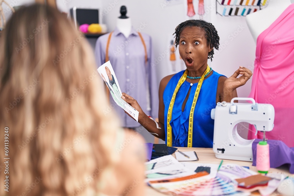 African woman with dreadlocks dressmaker designer at atelier with ...