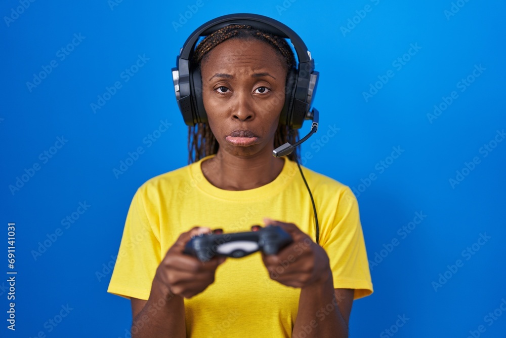 African american woman playing video games depressed and worry for ...
