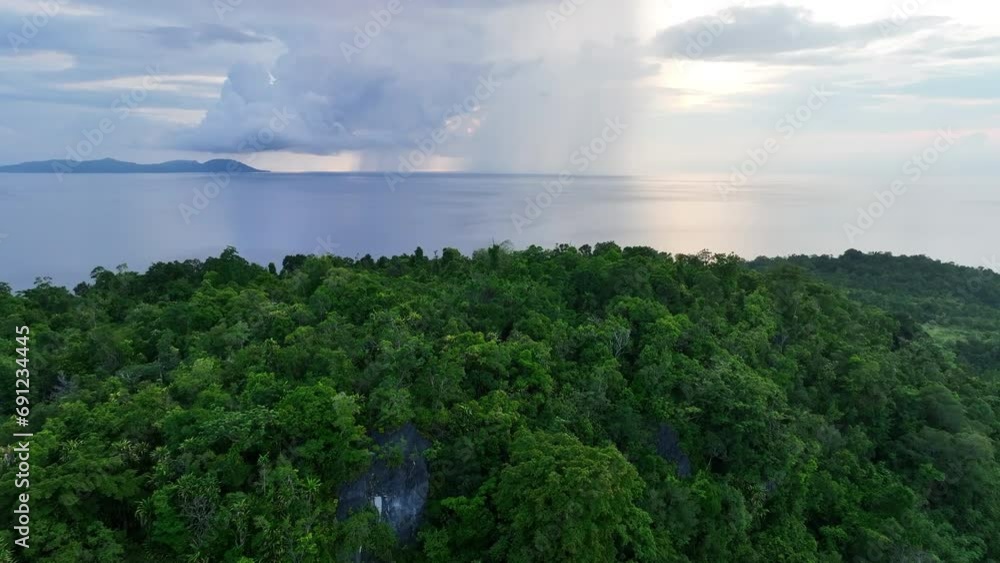 Early morning rain clouds drift near the beautiful island of Ambon ...