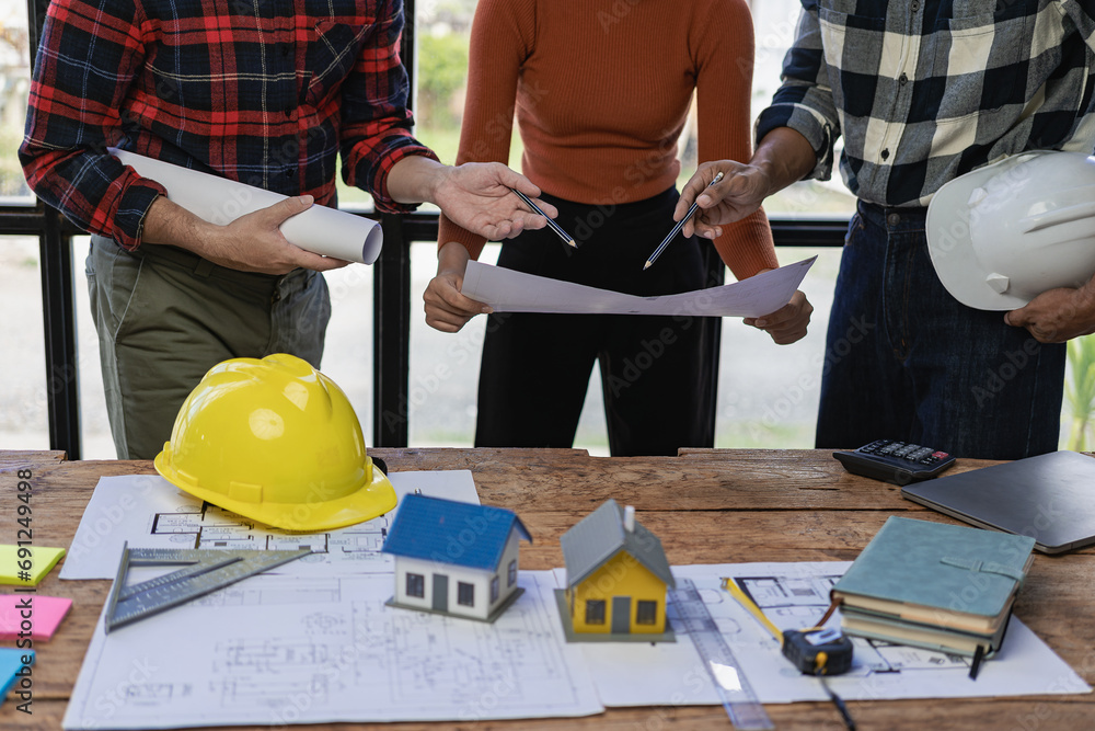 Construction engineers work on blueprints to build large commercial ...