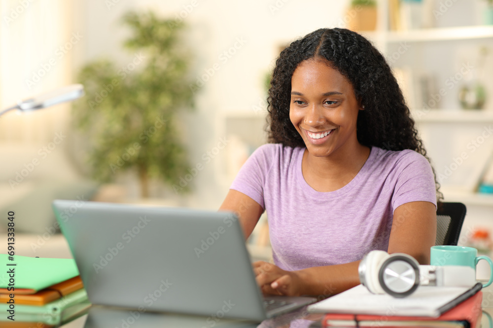 Happy black woman studying using laptop at home Stock Photo | Adobe Stock