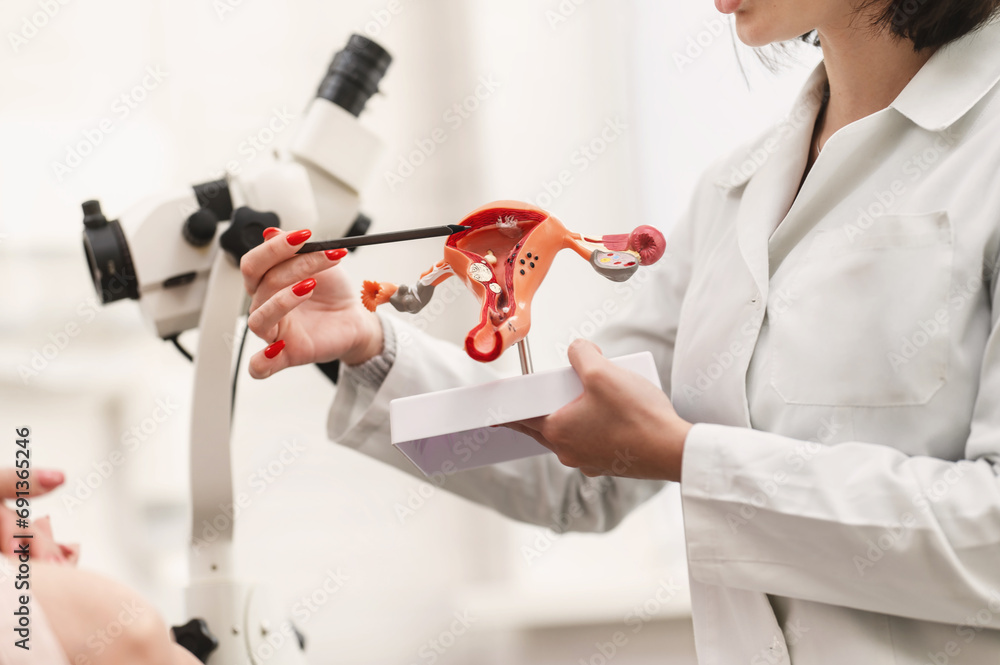 Medical examination in a gynecologist's chair, the doctor shows and ...