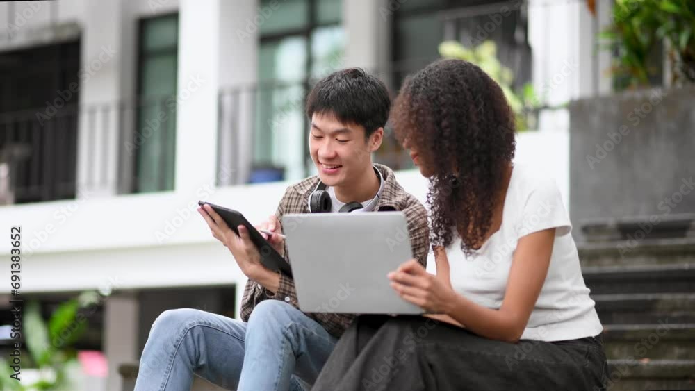 Two smart young college students focusing on his school project ...