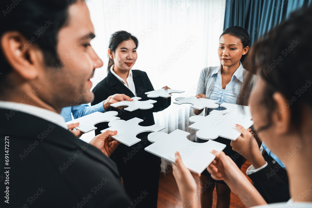 Multiethnic business people holding jigsaw pieces and merge them ...