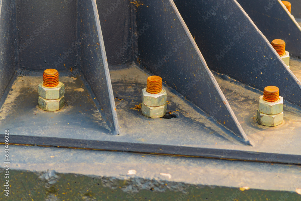 A metal billboard support fixed to a concrete foundation with studs and ...