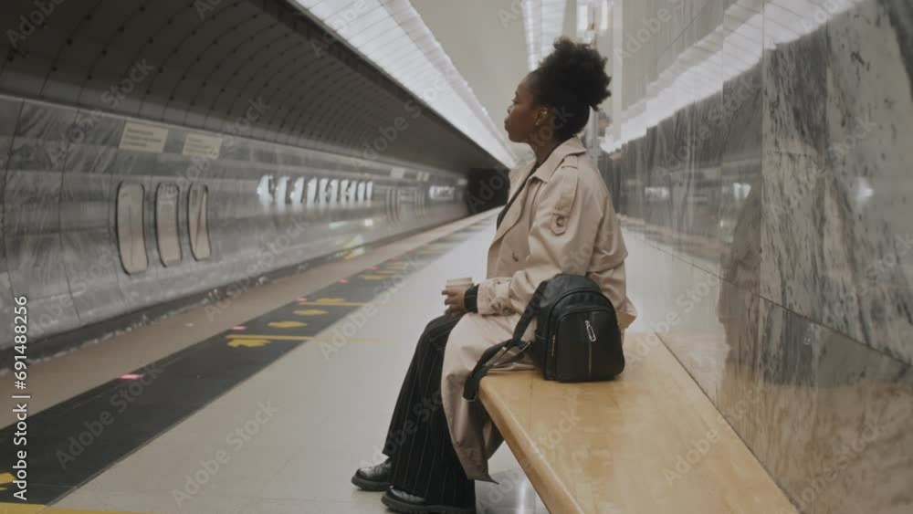 Long side view shot of young Black woman wearing long beige trench coat ...