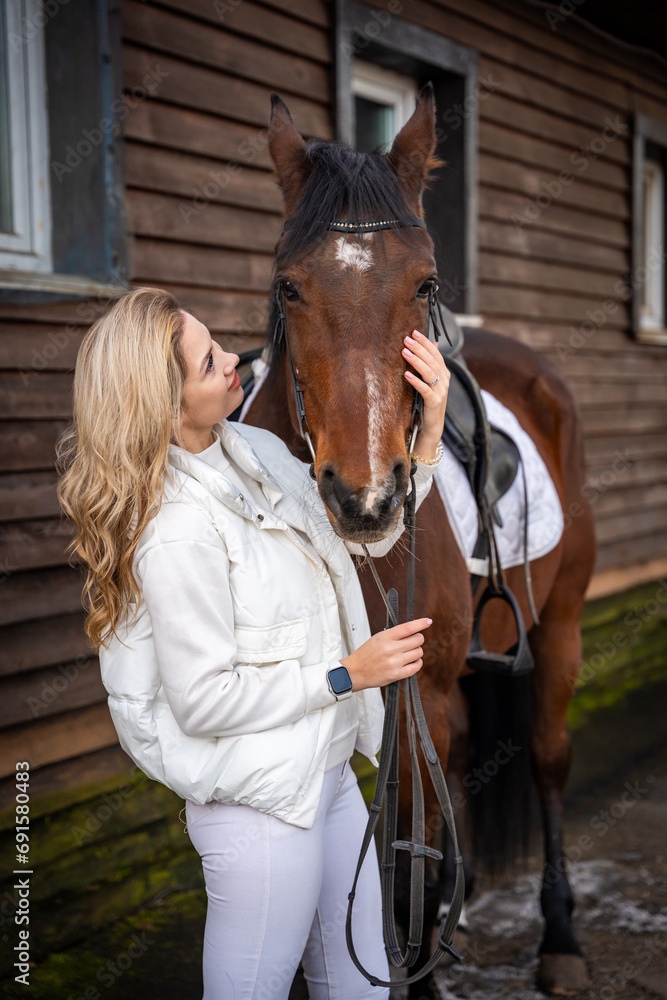 Young beautiful rider woman blonde with long hair in white clothes ...