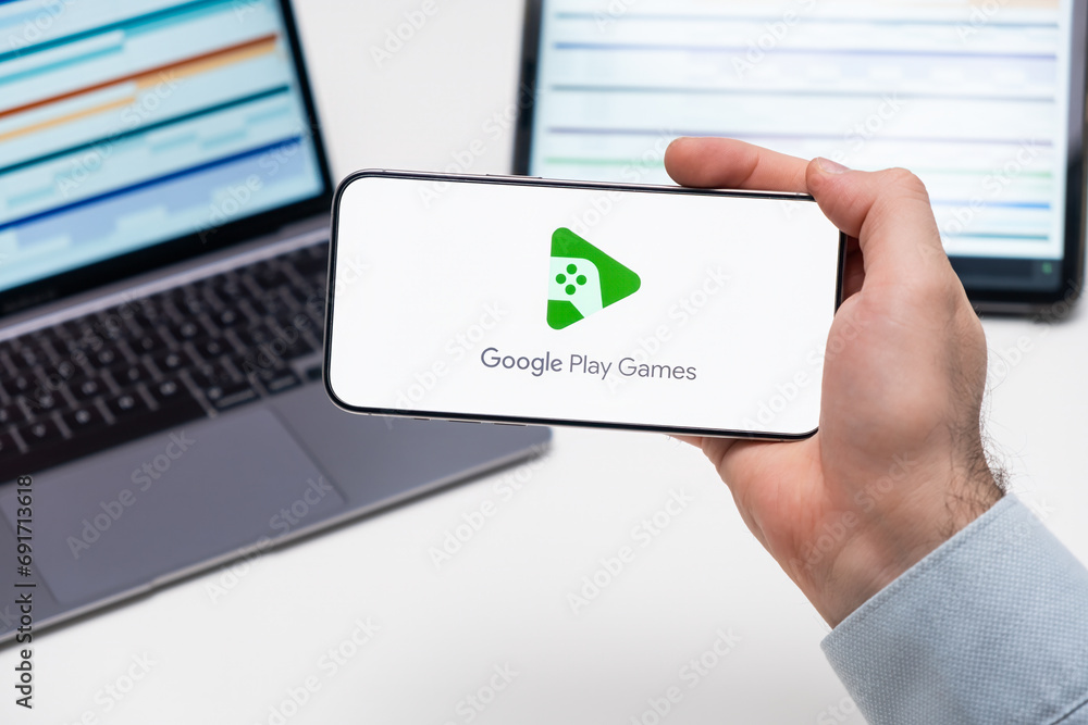 Google Play Games logo on the screen of a smartphone in mans hand with ...