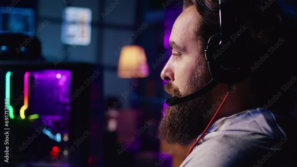 Zoom in on man enjoying coop FPS videogame, battling flying robots with ...