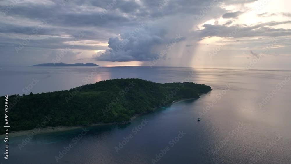 Early morning rain clouds drift near the beautiful island of Ambon ...