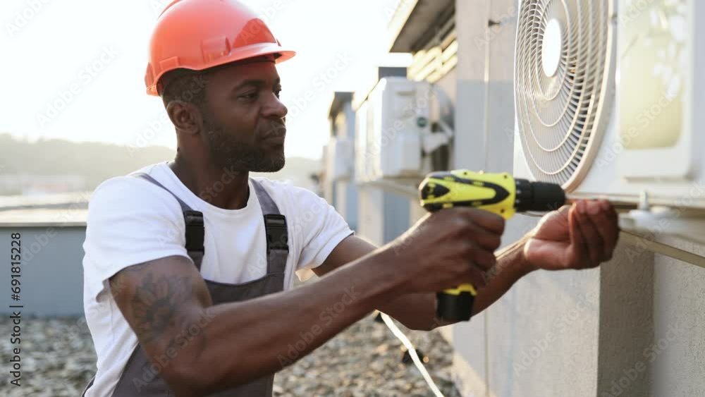 Portrait of handsome african american male using electrical screwdriver ...