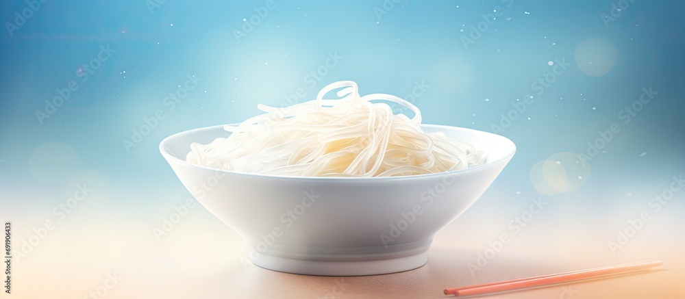 A white bowl of plain Chinese silver needle noodle also known as ...