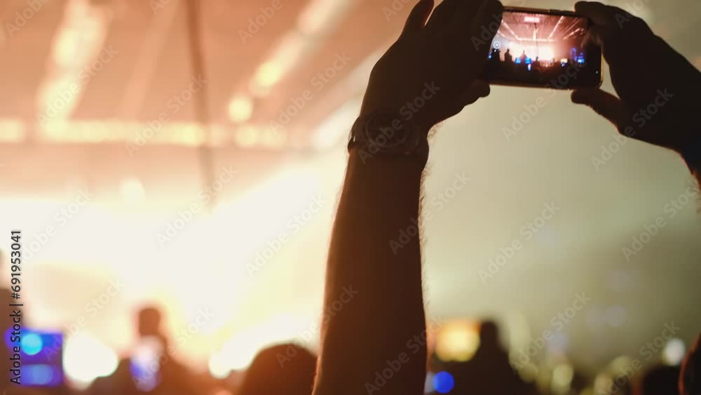 man's hands record video stories using a mobile phone. A crowd of fans ...