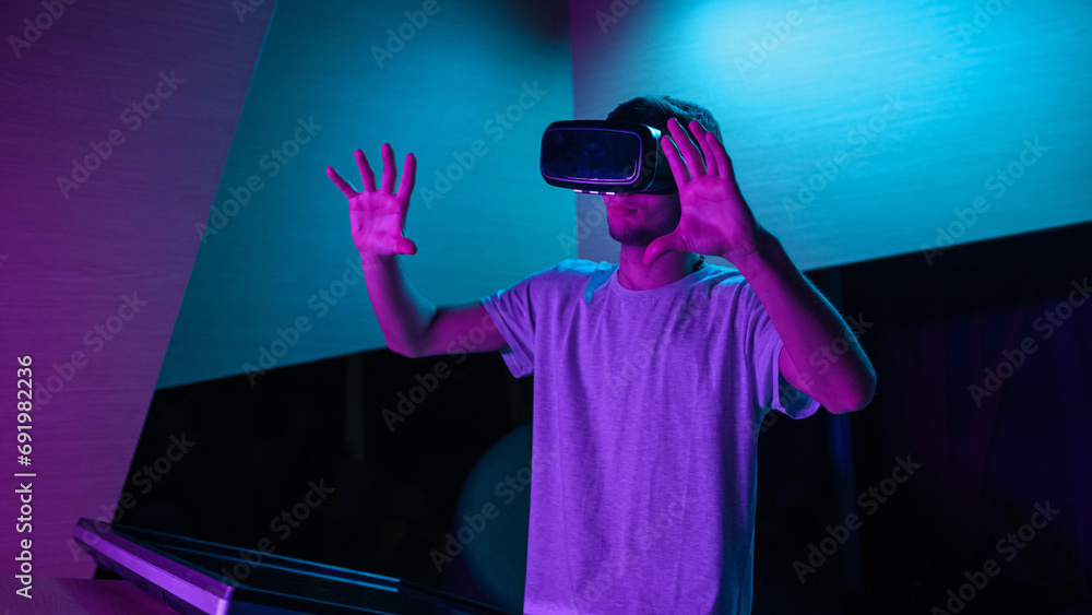 Young man with a VR headset having an immersive virtual reality ...