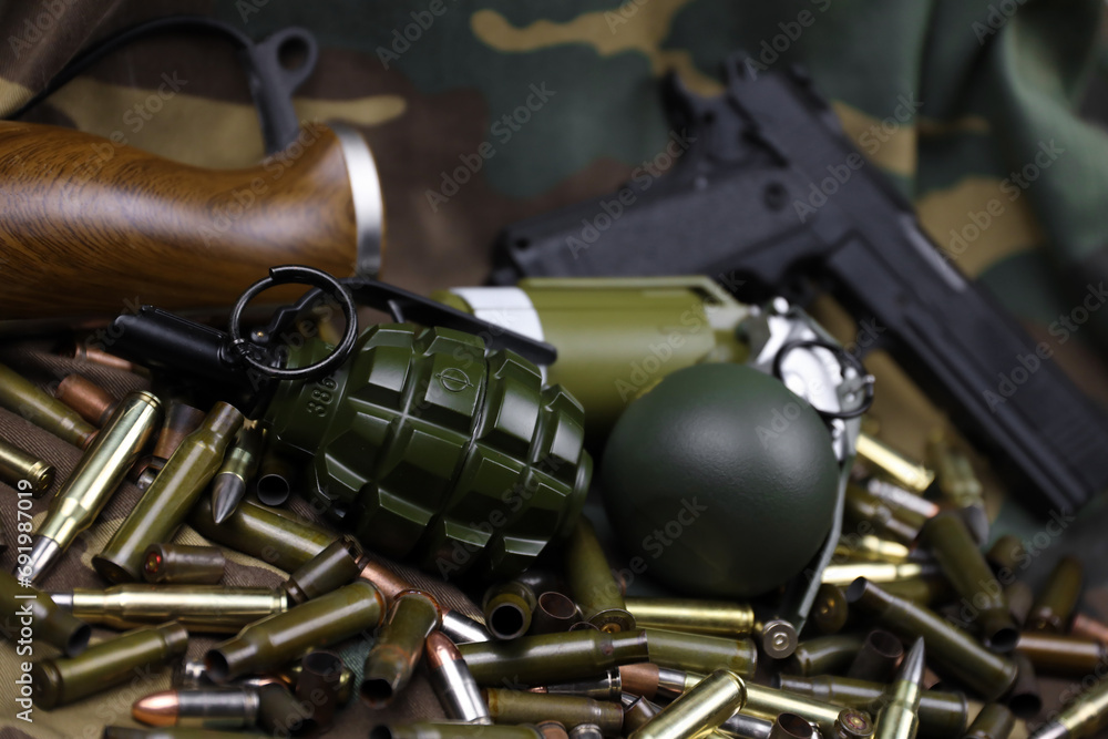 Different types of ammunition and grenades on a camouflage background ...
