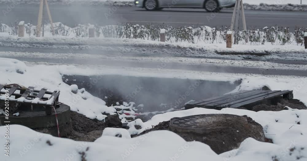 Steam coming out of the ground in an urban residential district, winter ...