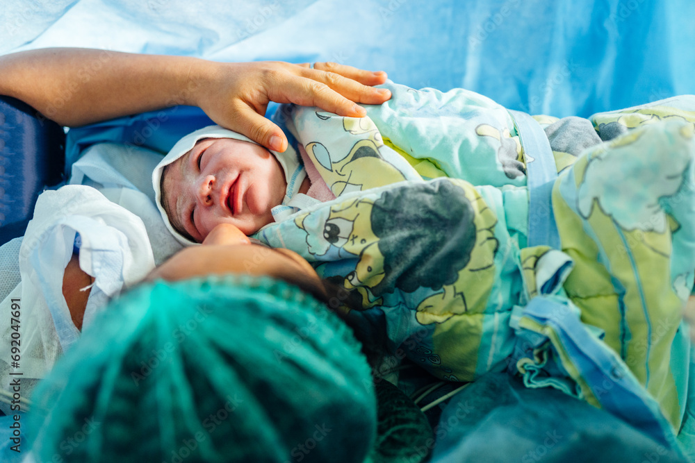 Mother holds newborn baby in hospital. Mother holding her newborn baby ...